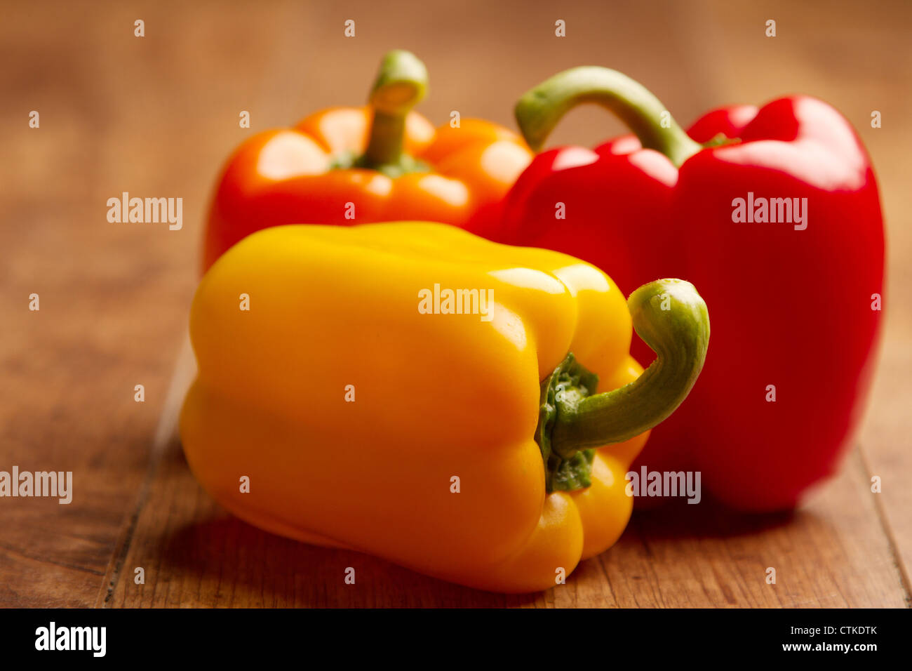 Three mixed peppers placed on a wooden background Stock Photo - Alamy