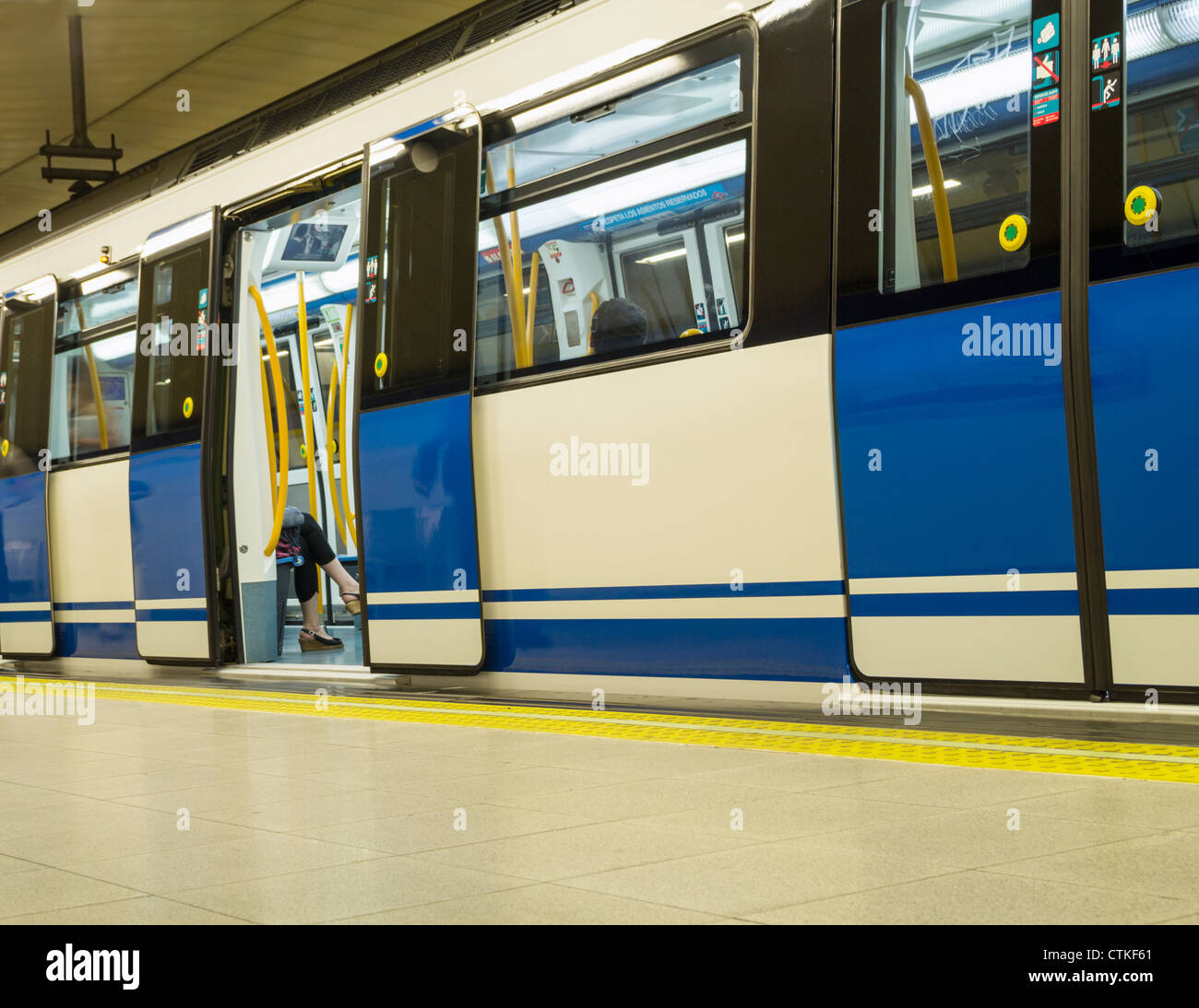 View of woman's legs on stationary train at Metro station in Madrid ...