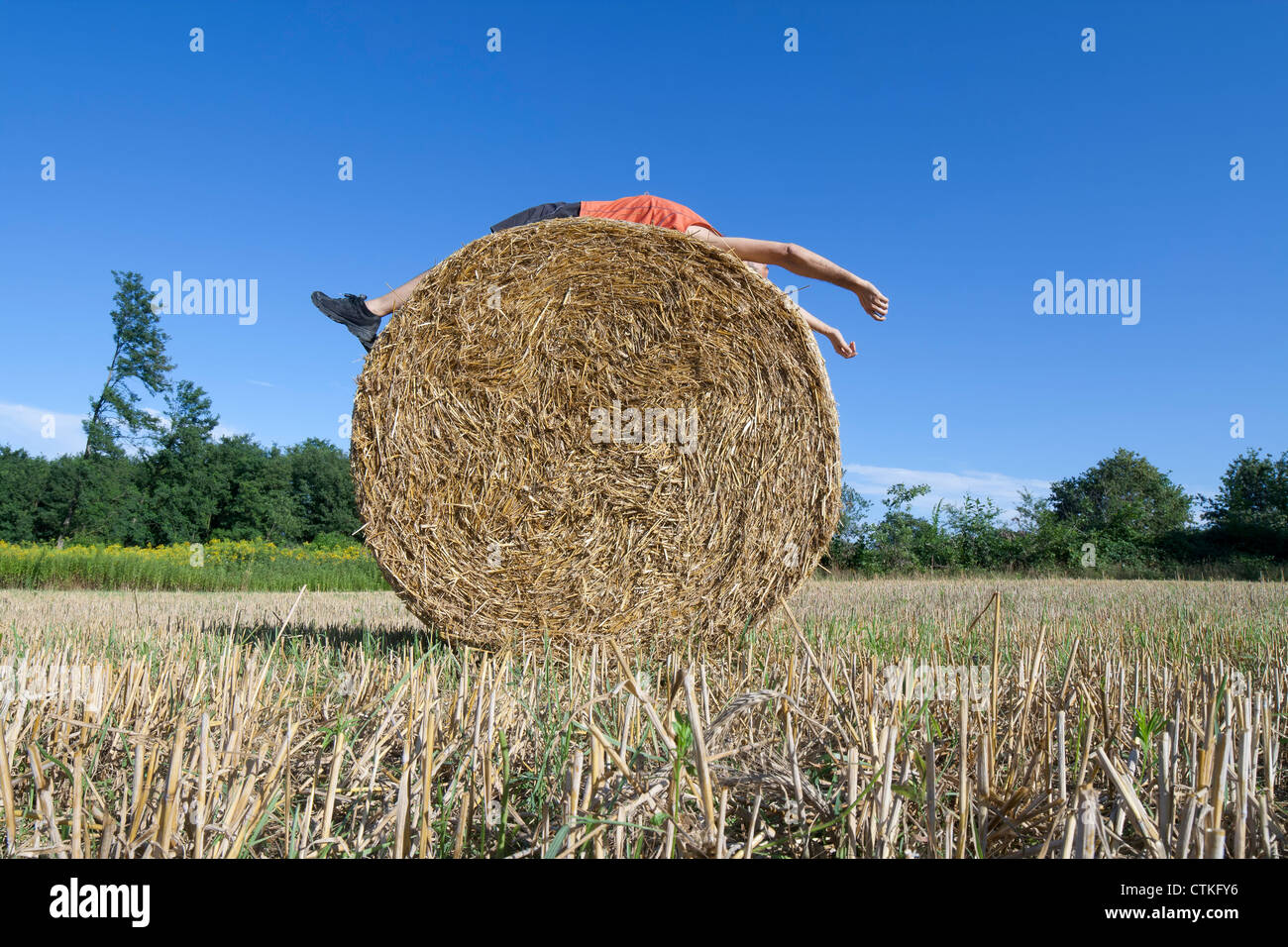 man lying down on hay bale in summer field Stock Photo - Alamy