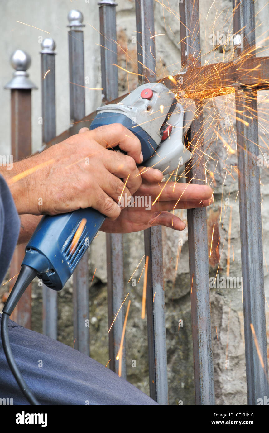 Hands of metal worker with grinder producing Stock Photo - Alamy