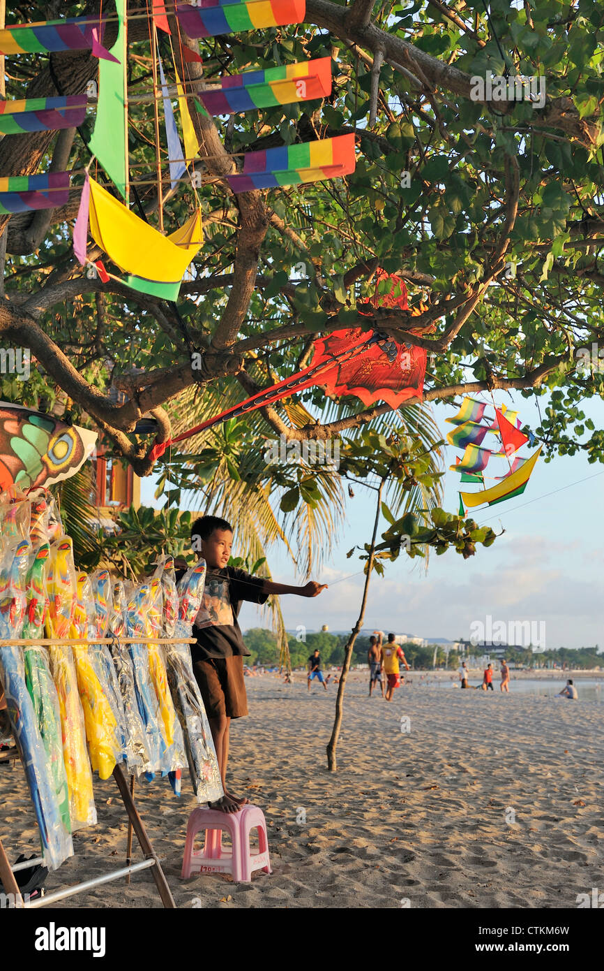 A boy plays with kites at his father's stall, Kuta Beach, Bali Stock ...