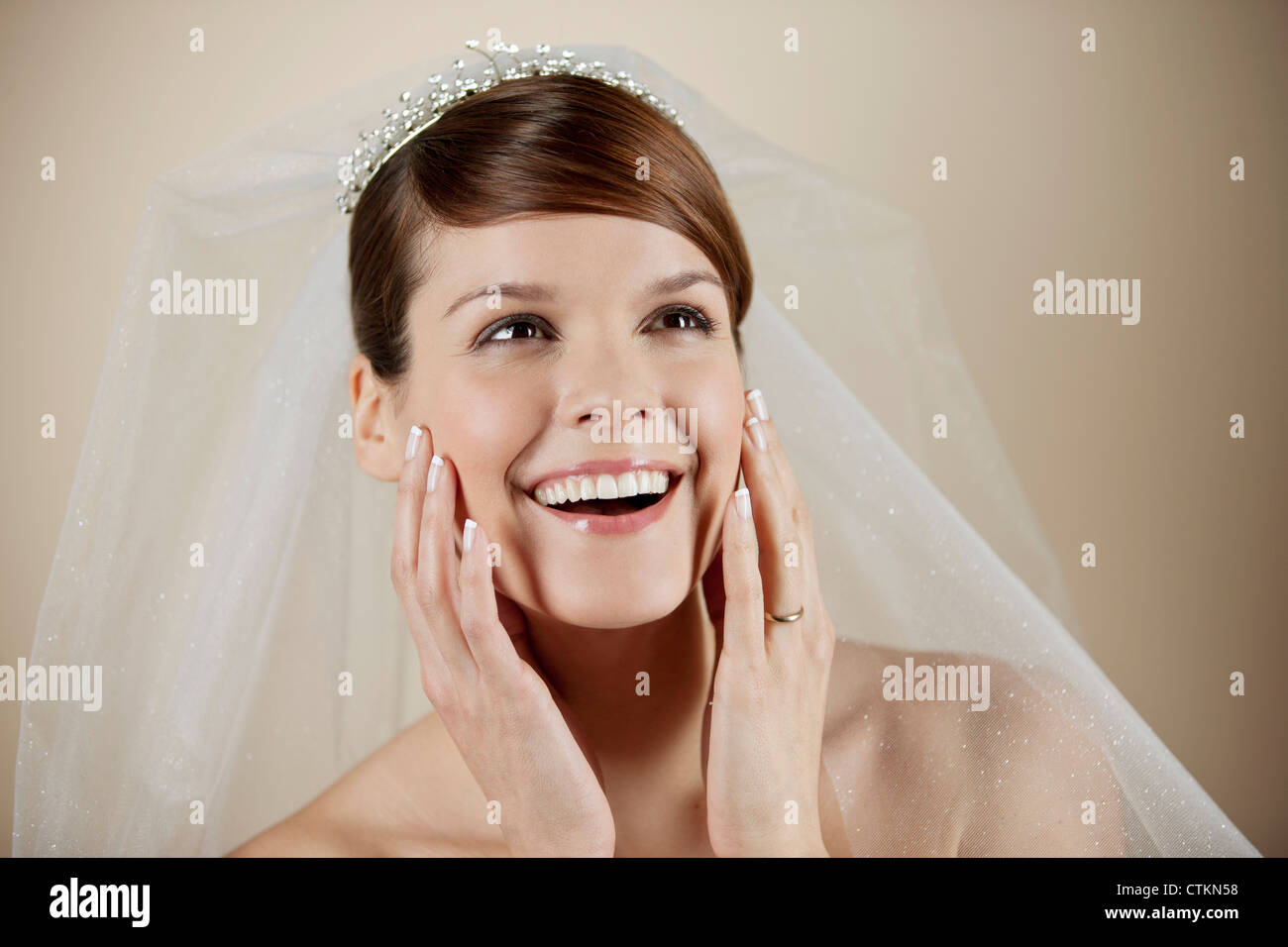 A young bride smiling, hands resting on her face Stock Photo - Alamy