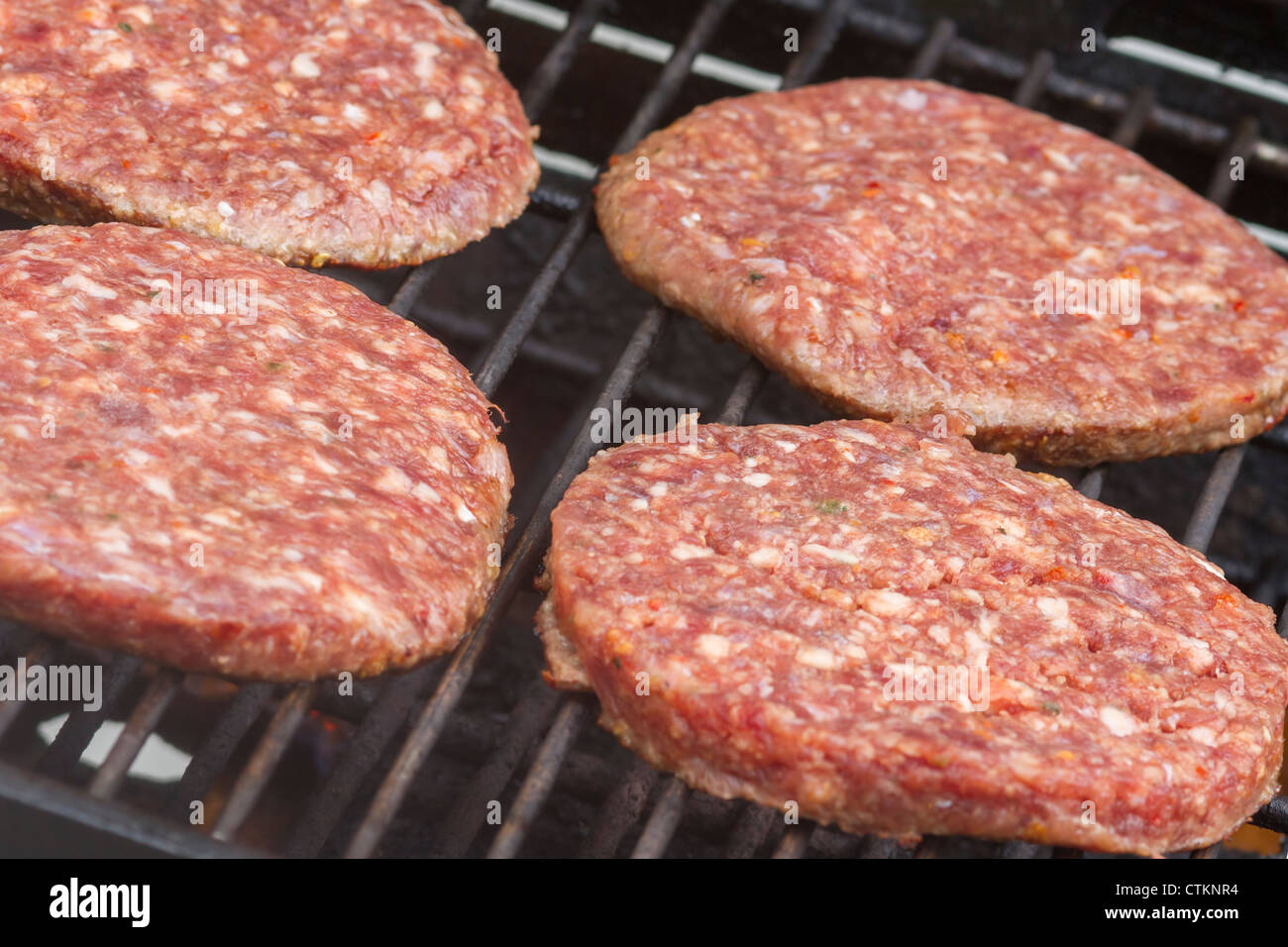 Raw Burgers on a Barbecue Grill close-up Stock Photo - Alamy