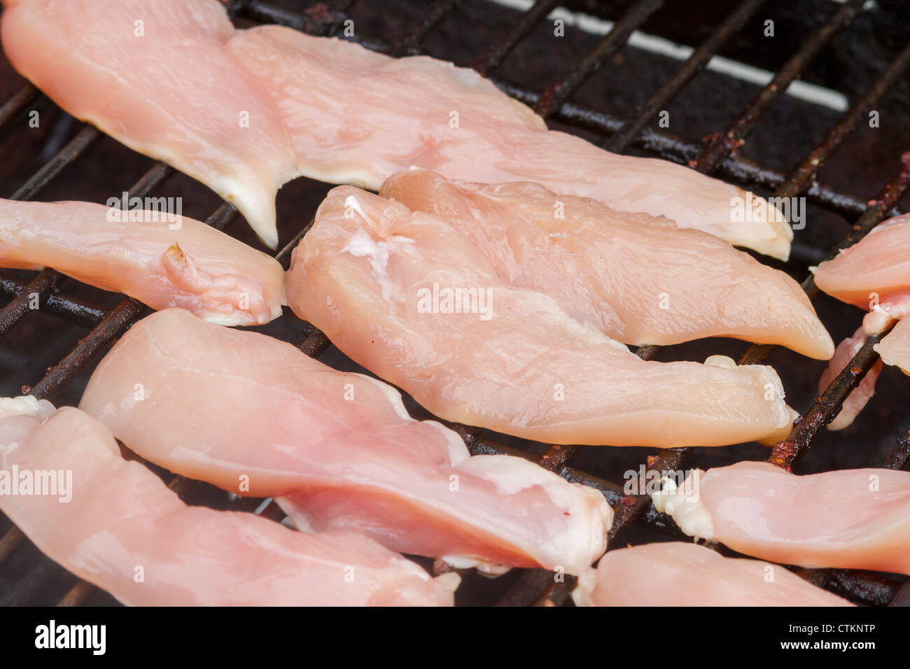 Raw Chicken on a Barbecue Grill close-up Stock Photo - Alamy