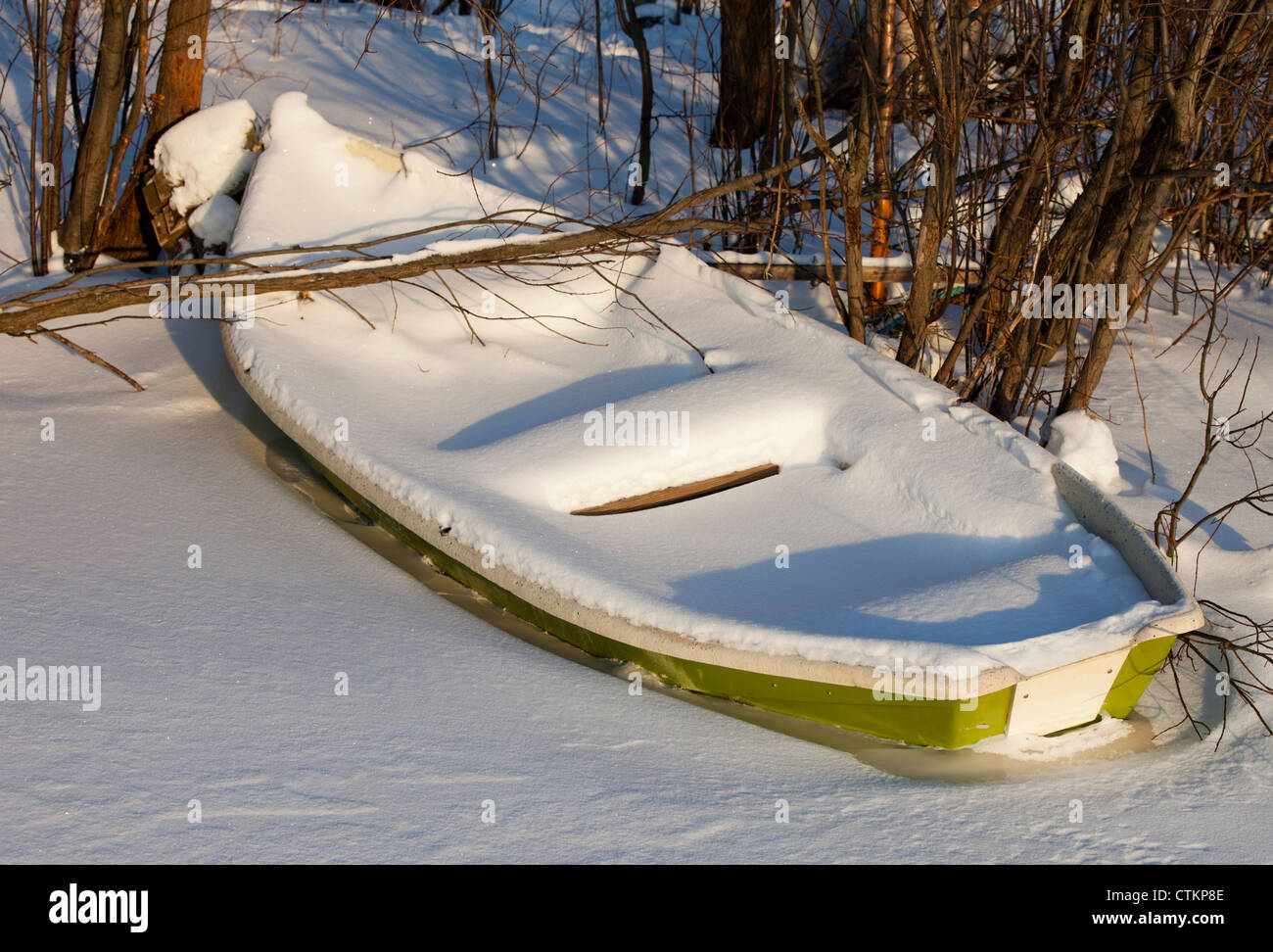 Isolated rowboat / skiff full of snow and stuck into ice , Finland ...