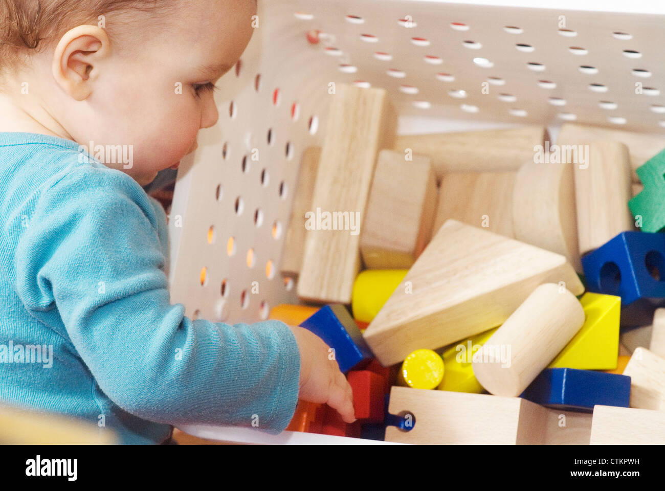 A young toddler looking at toys collected in a basket Stock Photo - Alamy