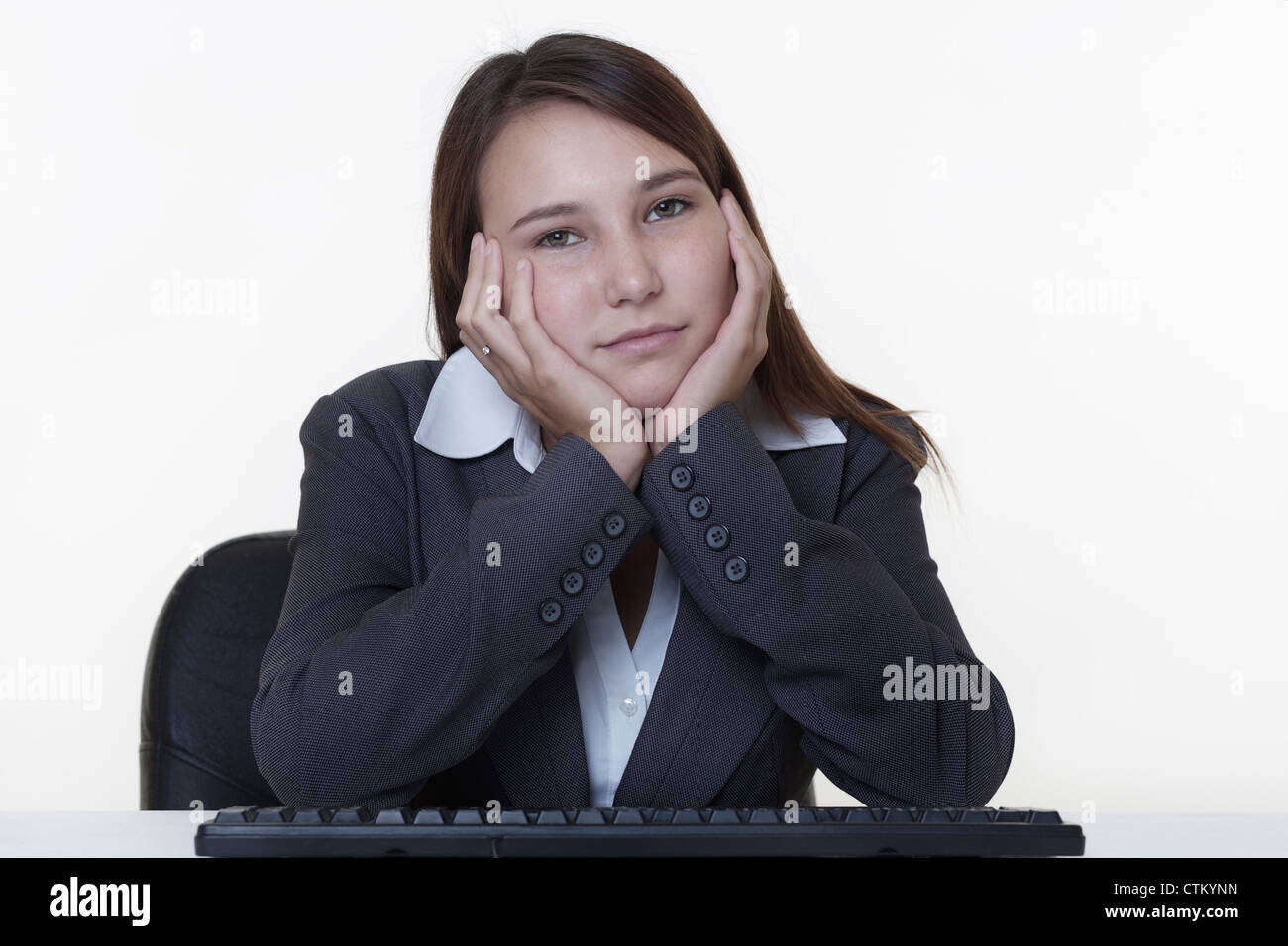 very young looking woman looking bored and not happy at work cant wait ...