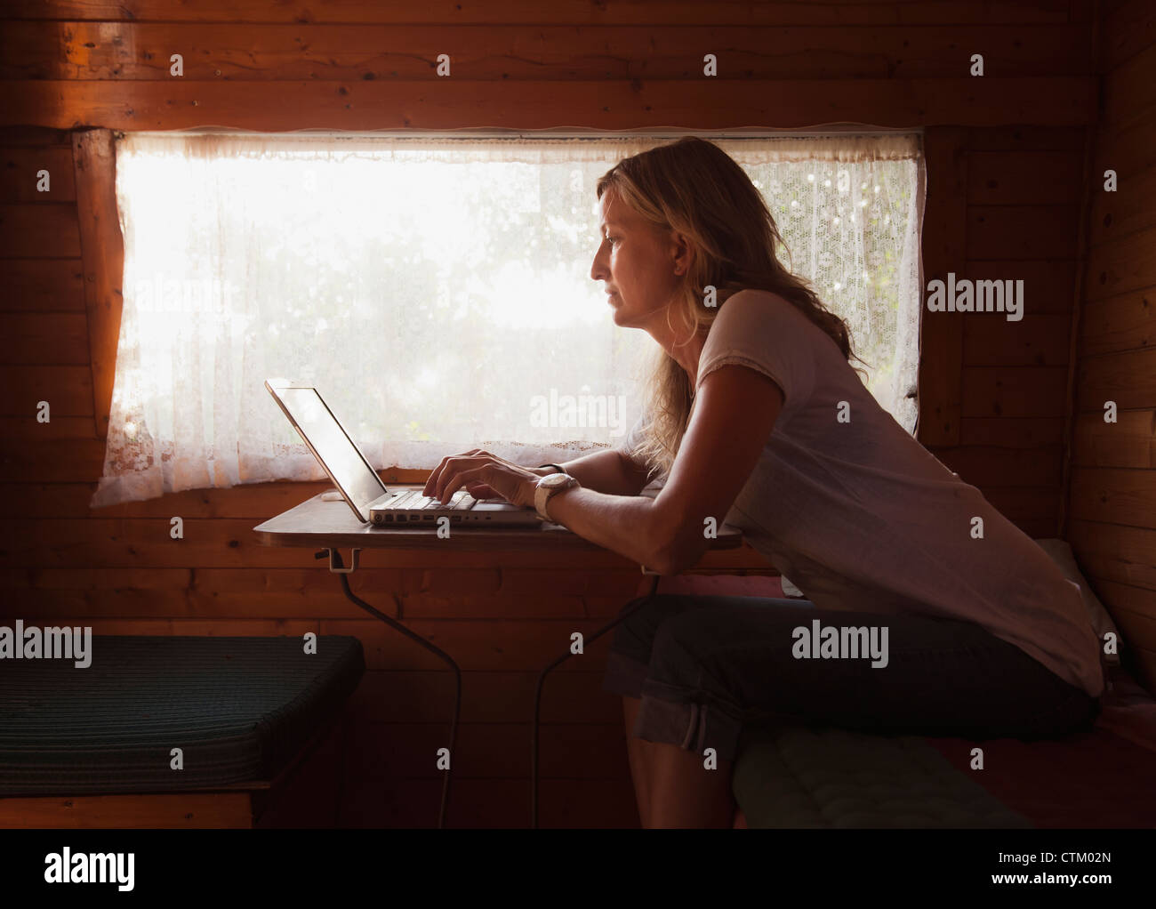 A Woman Sits Beside A Window Working On Her Computer; Tarifa, Cadiz ...
