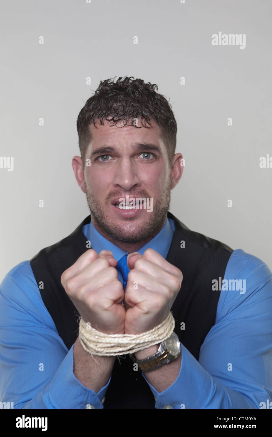 handsome man with his wrist tied up with string so he cant do any work ...