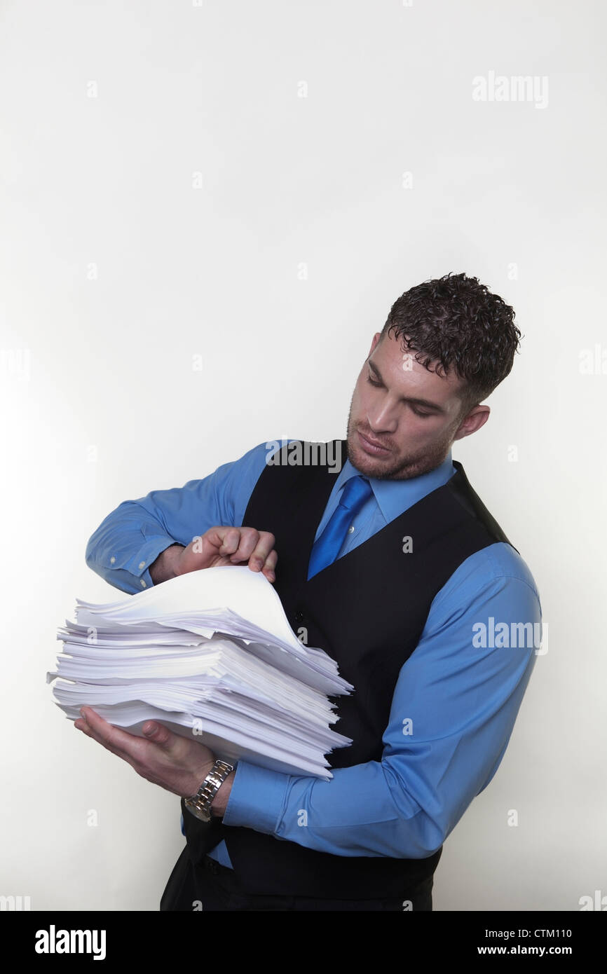 man holding a large pile of paper work in his arms Stock Photo - Alamy