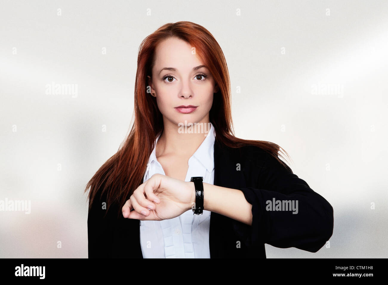 woman in a suit looking at her watch Stock Photo - Alamy