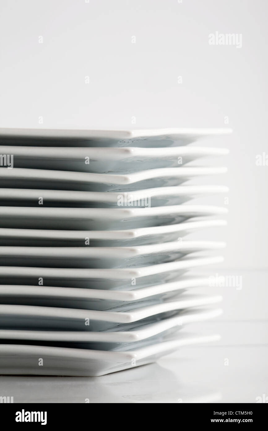 Stack Of White Square Plates On A White Background Stock Photo - Alamy