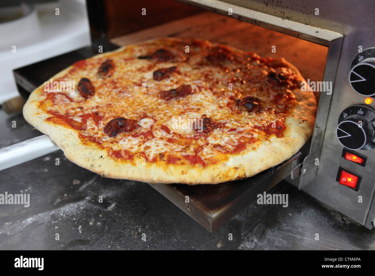 Stages of pizza preparation placing the pizza in the oven Stock Photo ...