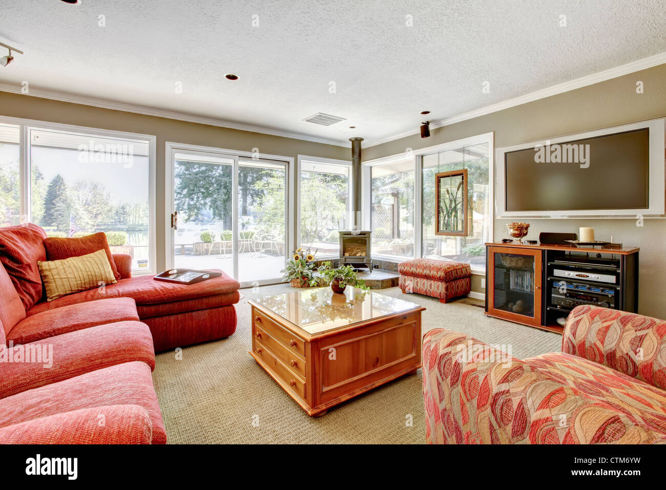 Nice bright living room with Tv and red sofa Stock Photo - Alamy