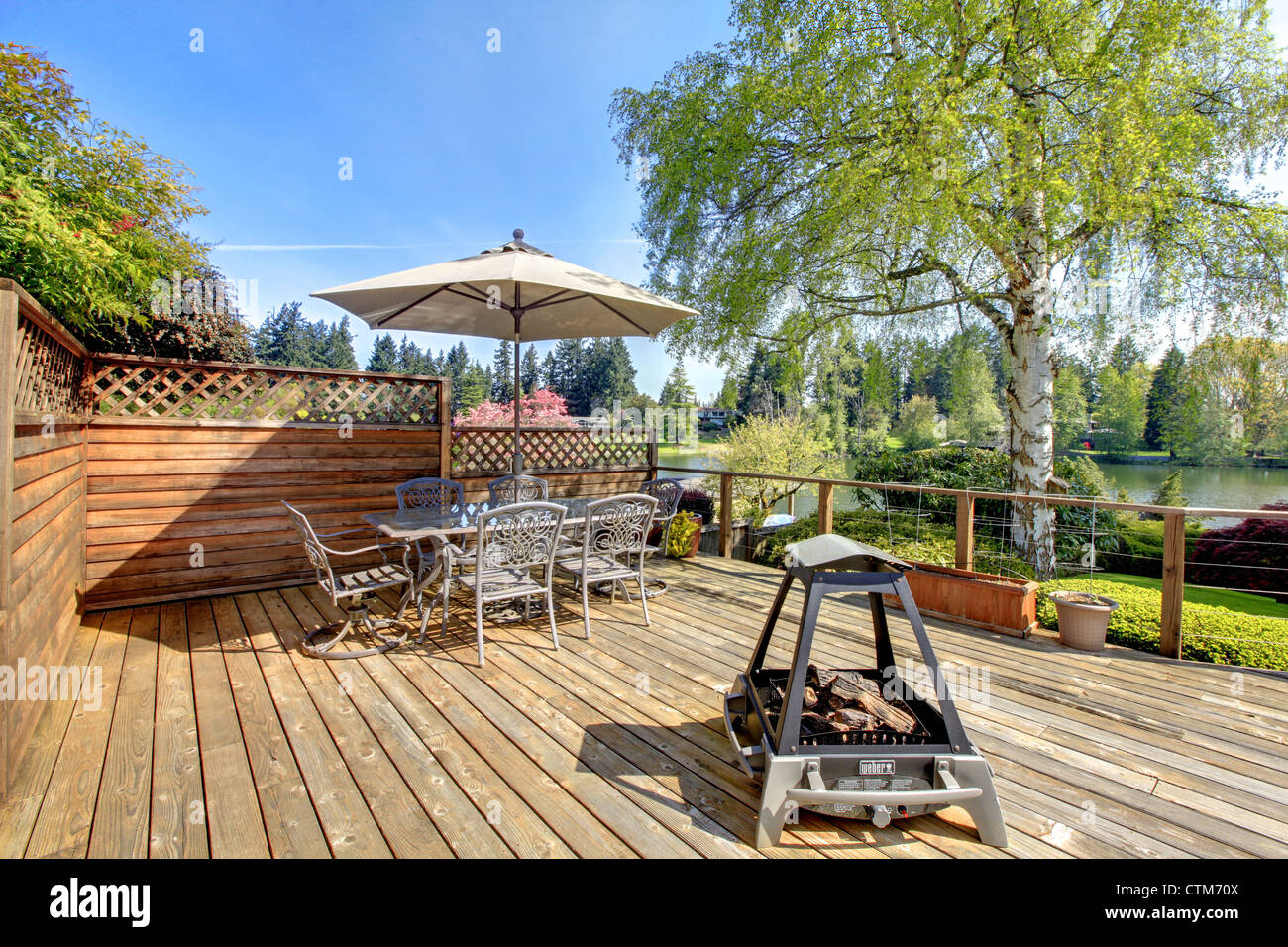 Beautiful spring deck with umbrella and fire pit Stock Photo - Alamy