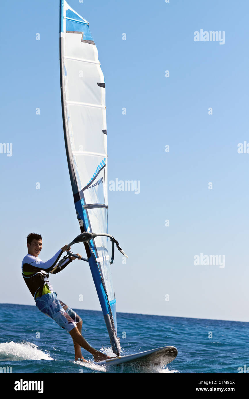 Side view of young man happily surfing the wind Stock Photo - Alamy