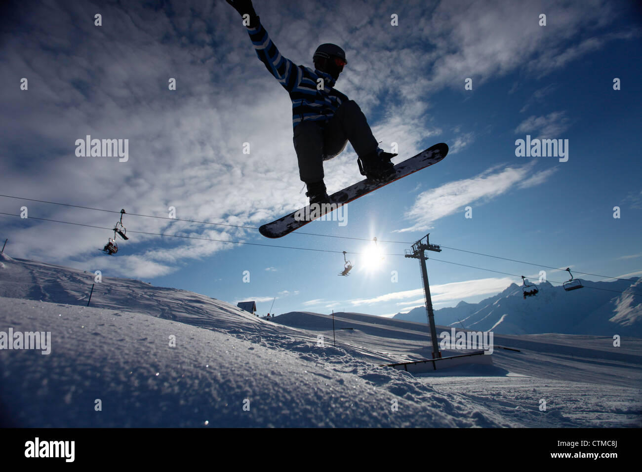 jumping snowboarder facing the sun Stock Photo - Alamy