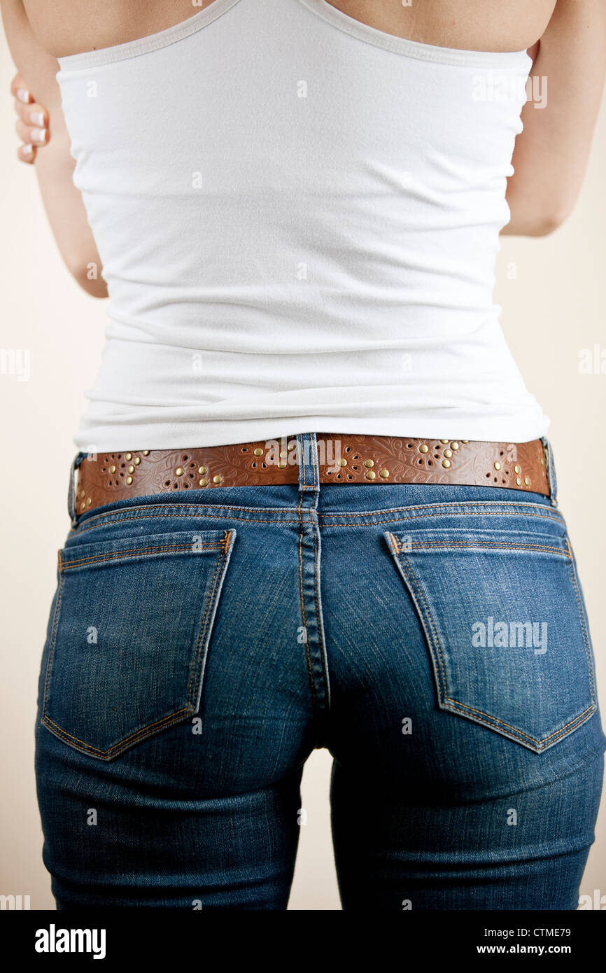 A young womans wearing jeans and a white vest, cropped rear view Stock ...