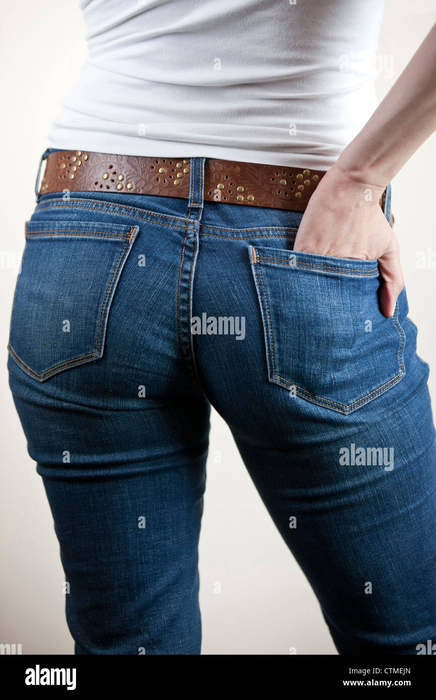 A young womans wearing jeans and a white vest, cropped rear view Stock ...