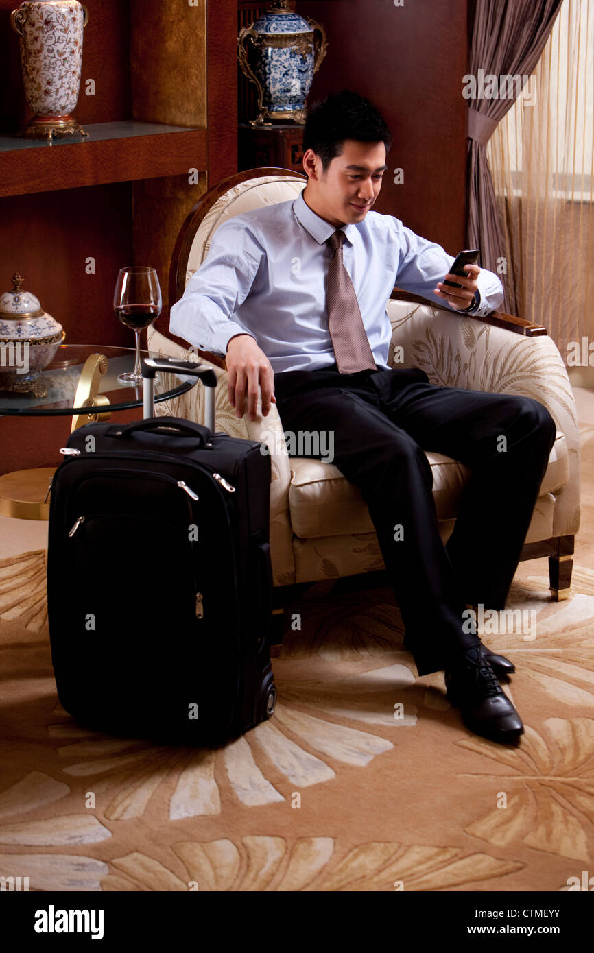 Young businessman using mobile phone in hotel Stock Photo - Alamy