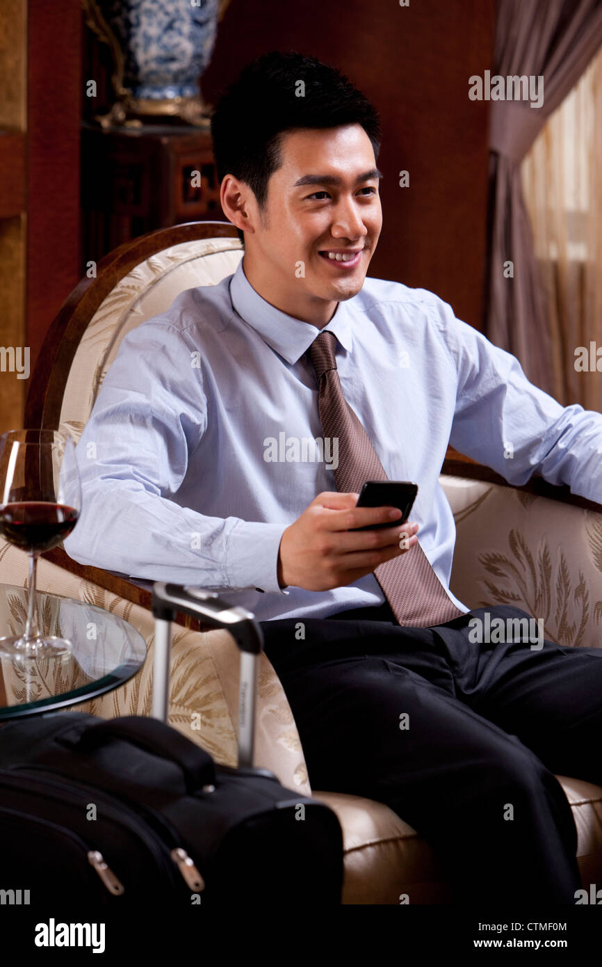 Young businessman using mobile phone in hotel Stock Photo - Alamy