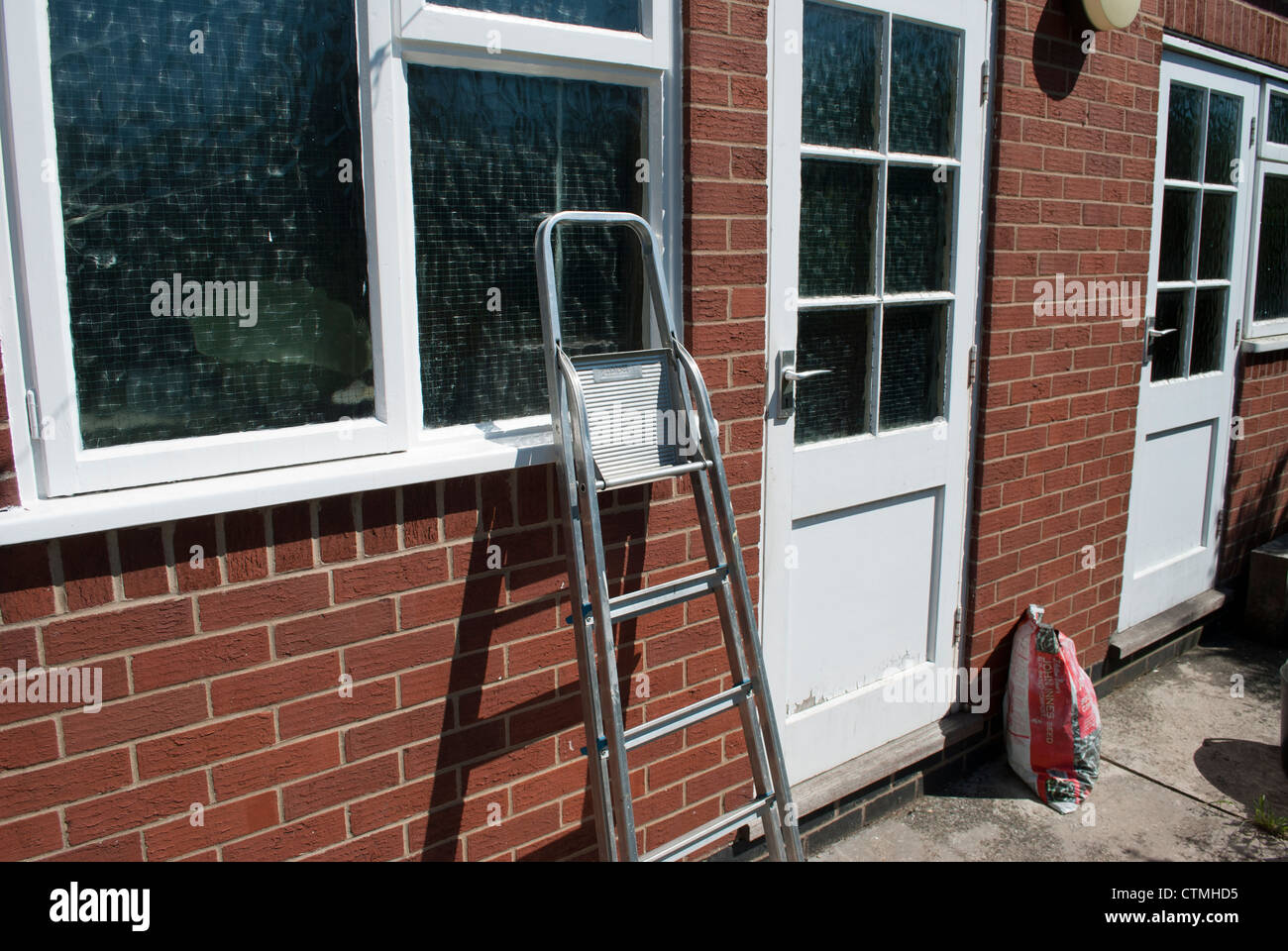 Step ladder leaning against a window Stock Photo - Alamy