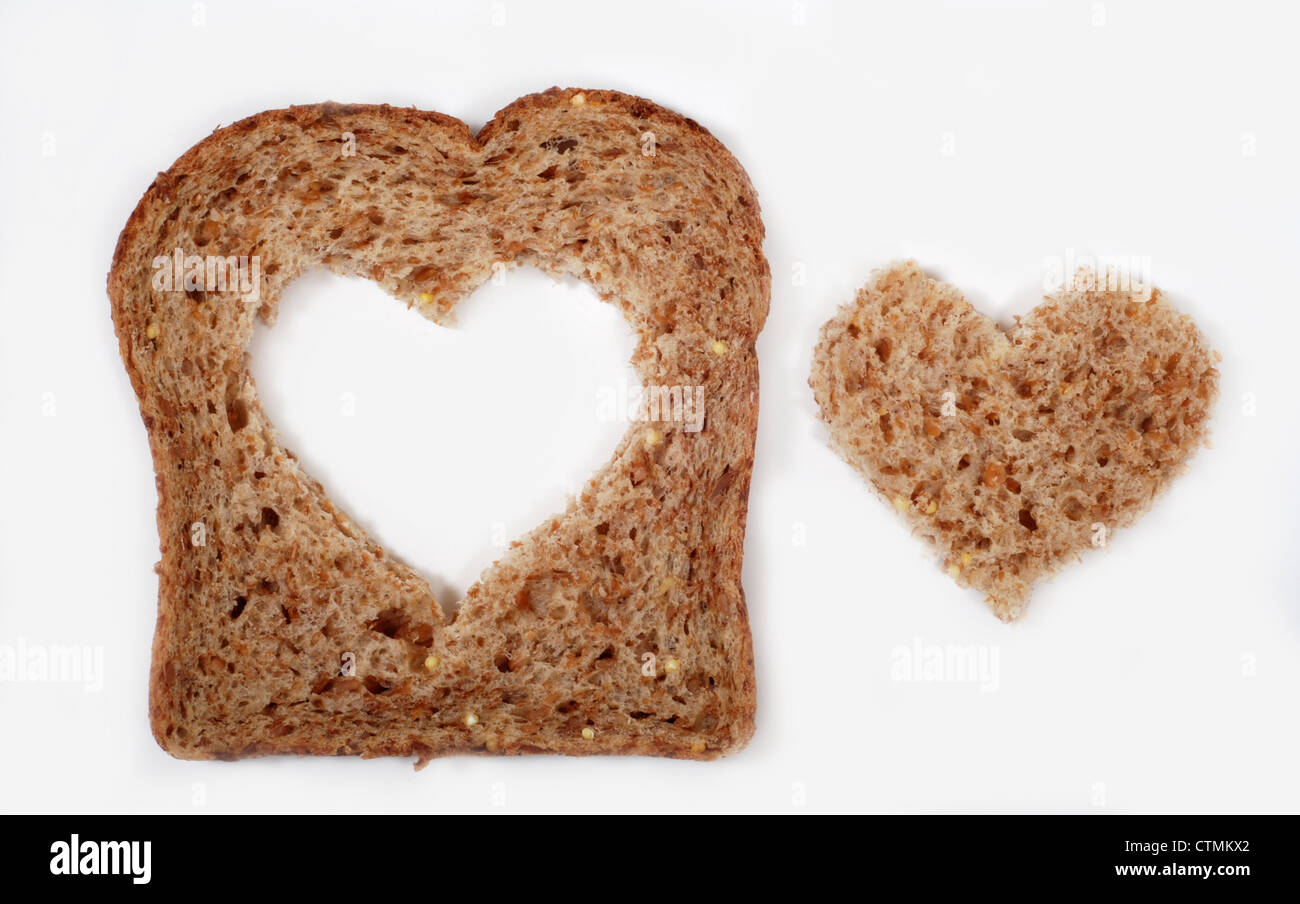 A slice of whole wheat bread with a heart shape cut from the center ...