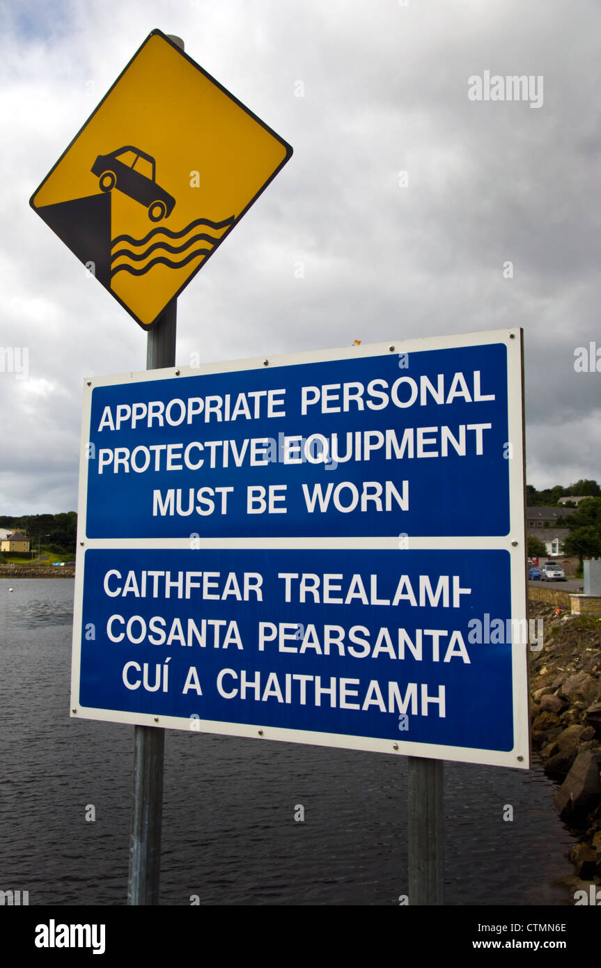 Warning signs in English and Irish Gaelic language on harbour side quay ...