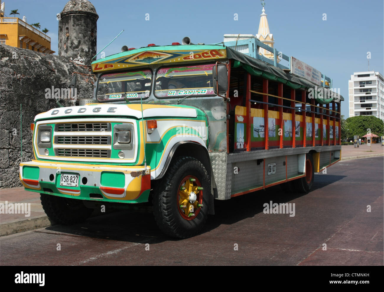 Brightly decorated tour bus picking up passengers in Old City Cartagena ...