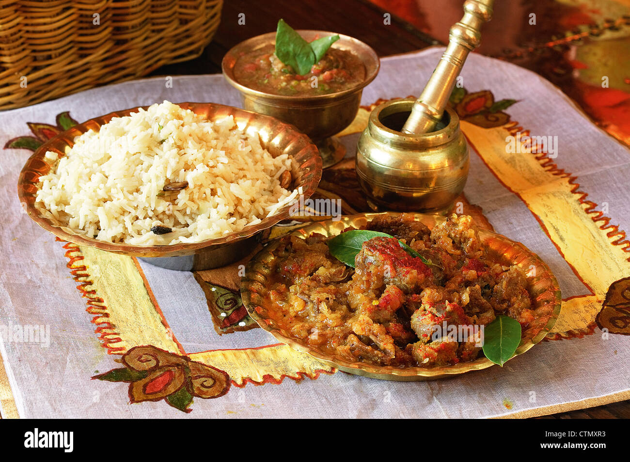 Indian cooking. Sweet-sour lamb cubes served with rice and limri ...
