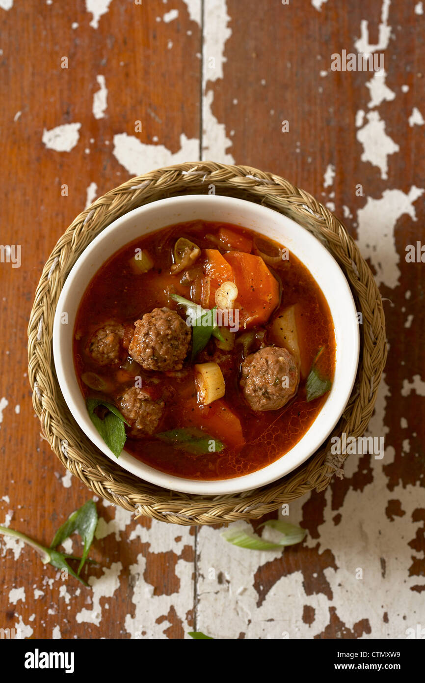 Traditional African cooking. Tomato and meatball soup with spring ...