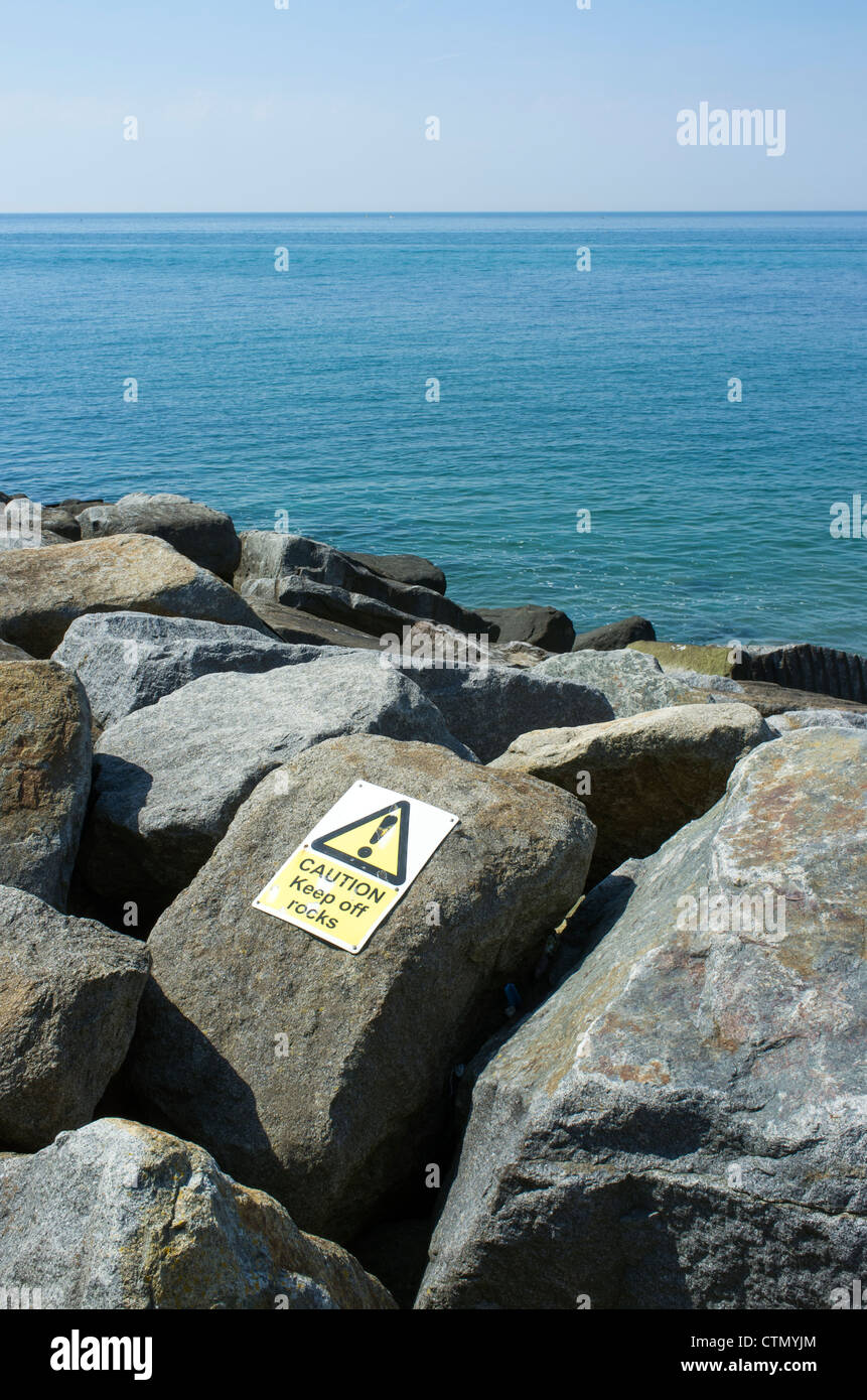Caution keep off rocks notice attached to a rock at West Bay in Dorset ...