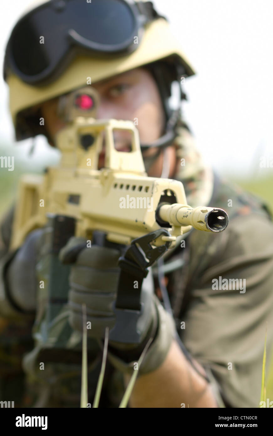 Young soldier with automatic rifle and combat ammunition outdoors Stock ...