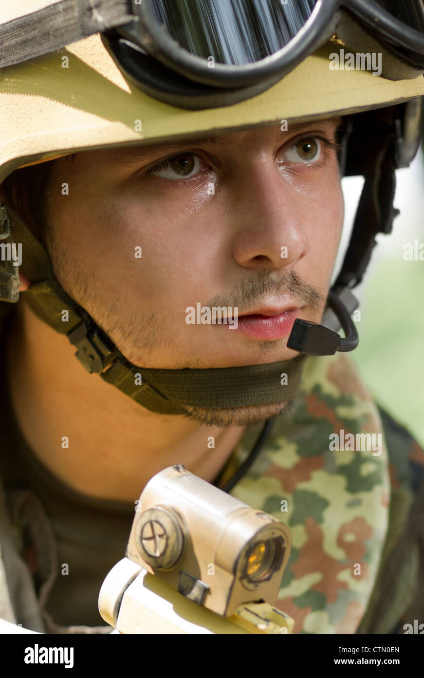 Young soldier with automatic rifle and combat ammunition outdoors Stock ...