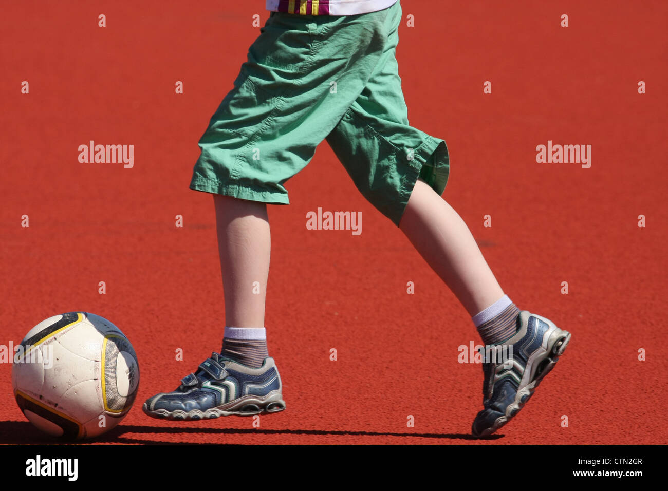Child playing football on red Stock Photo - Alamy