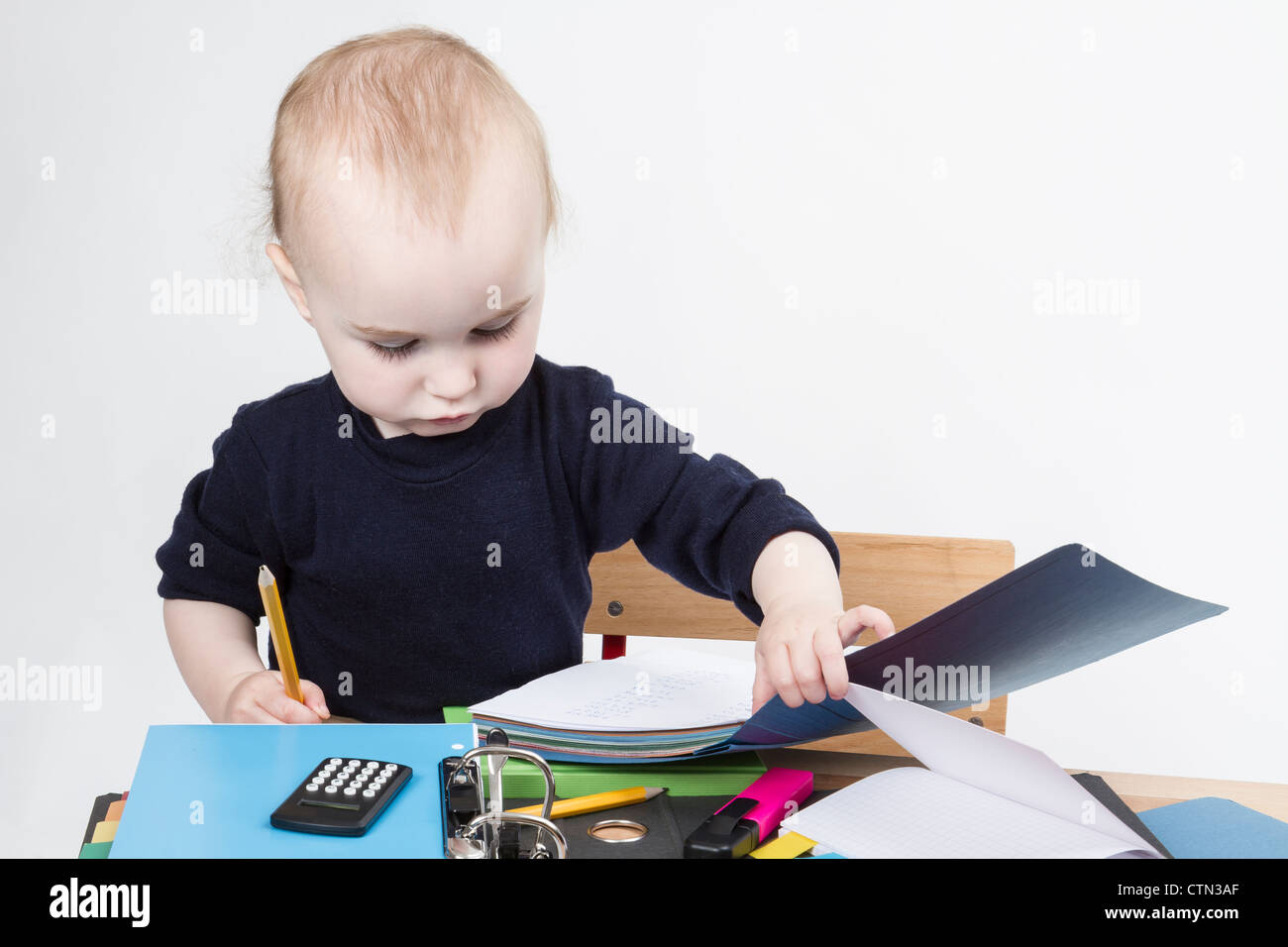 young child working at writing desk in light background Stock Photo - Alamy