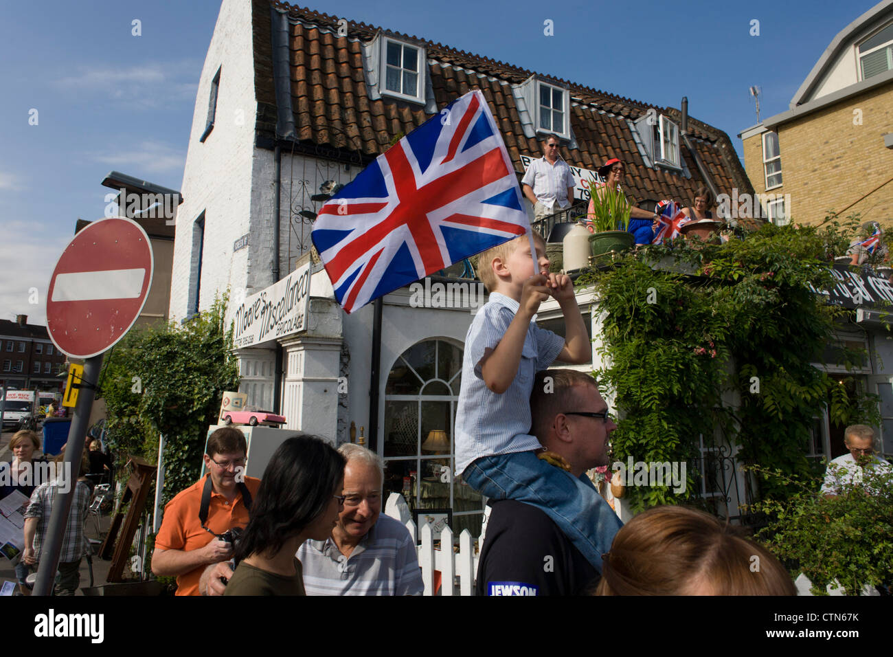 Young boy on father's shoulders hold flag aloft on the first day of ...