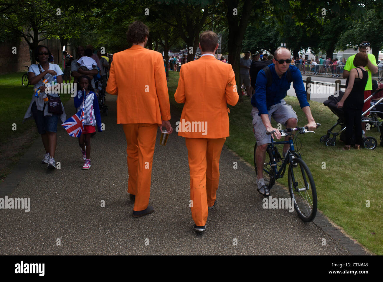 Two Dutch spectators wearing matching orange suits walk along an evenue ...