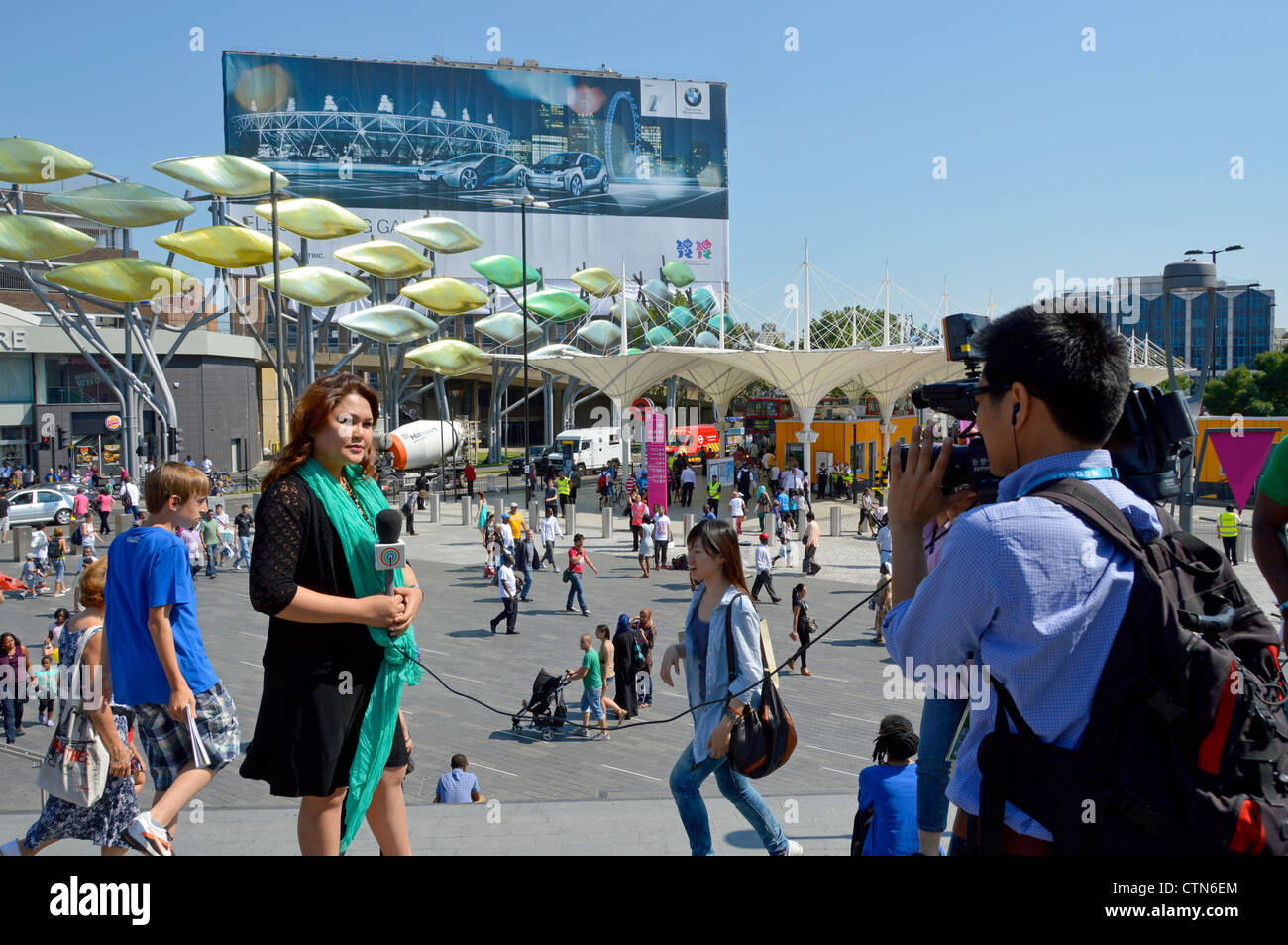 Video camera operator recording reporter at Stratford bus station ...