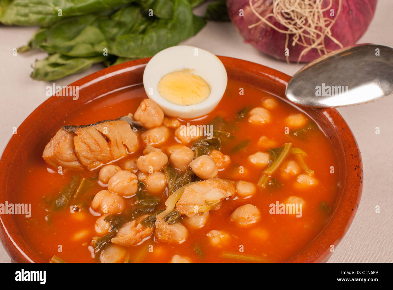 Chickpea stew with spinach and cod served in a clay pot Stock Photo - Alamy