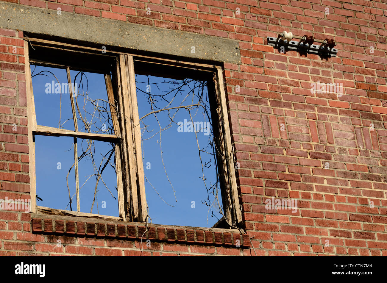 Window frame and electrical insulators remain on brick building wall ...