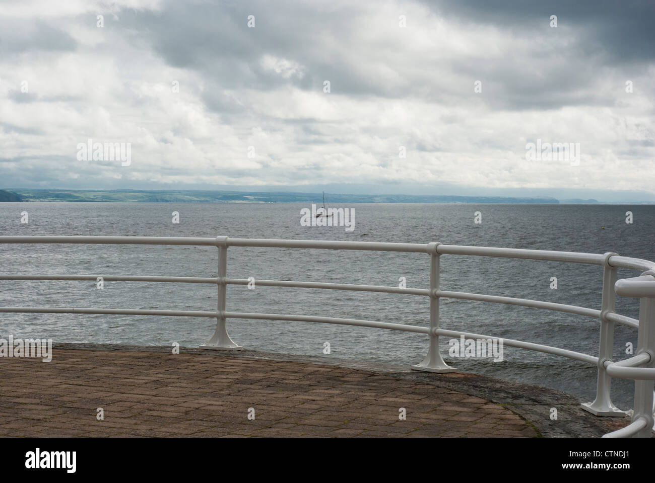 Distant boat at sea, as seen from over the promenade Stock Photo - Alamy