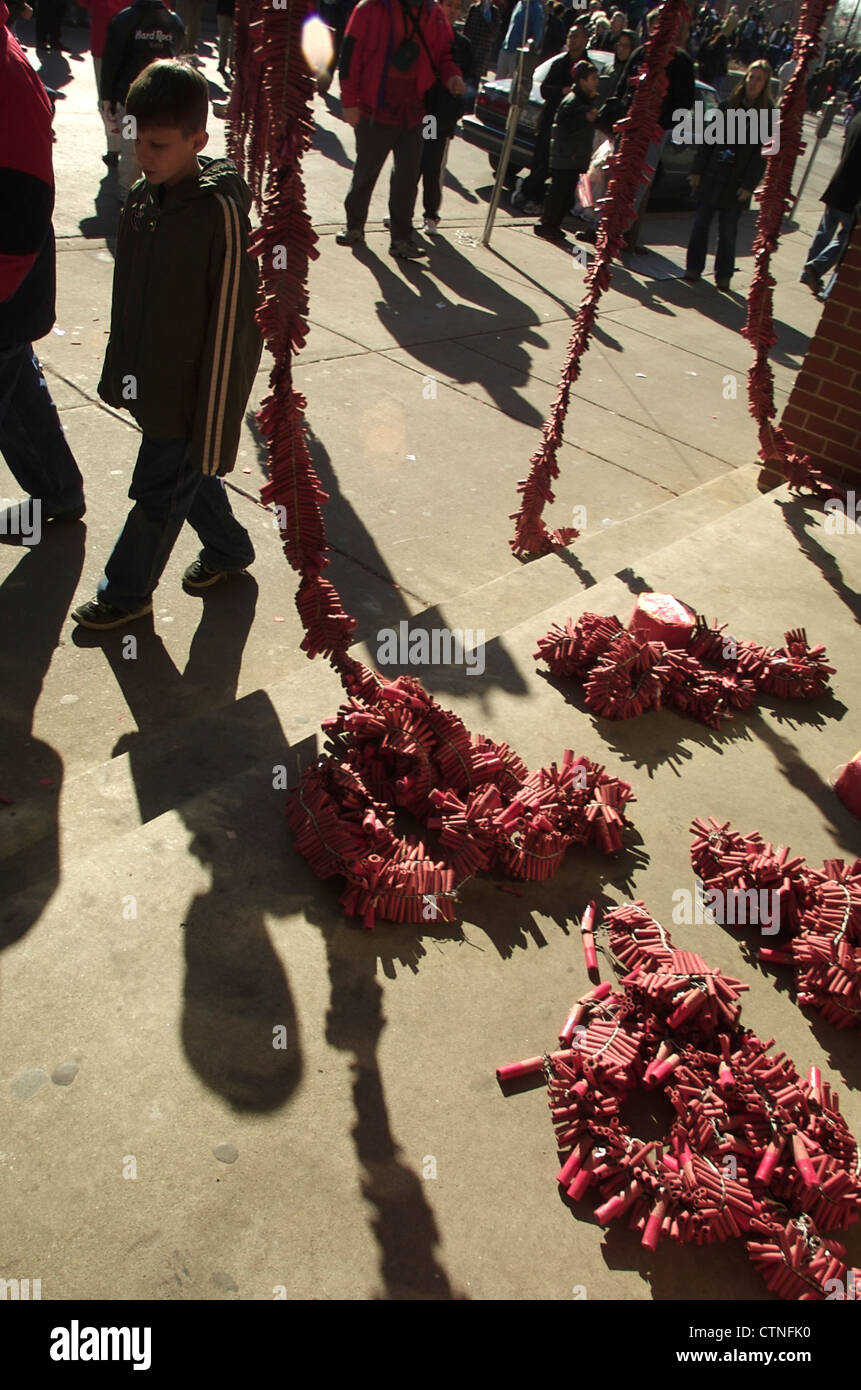 People walk by firecrackers to be used Chinese New Year celebrations in ...