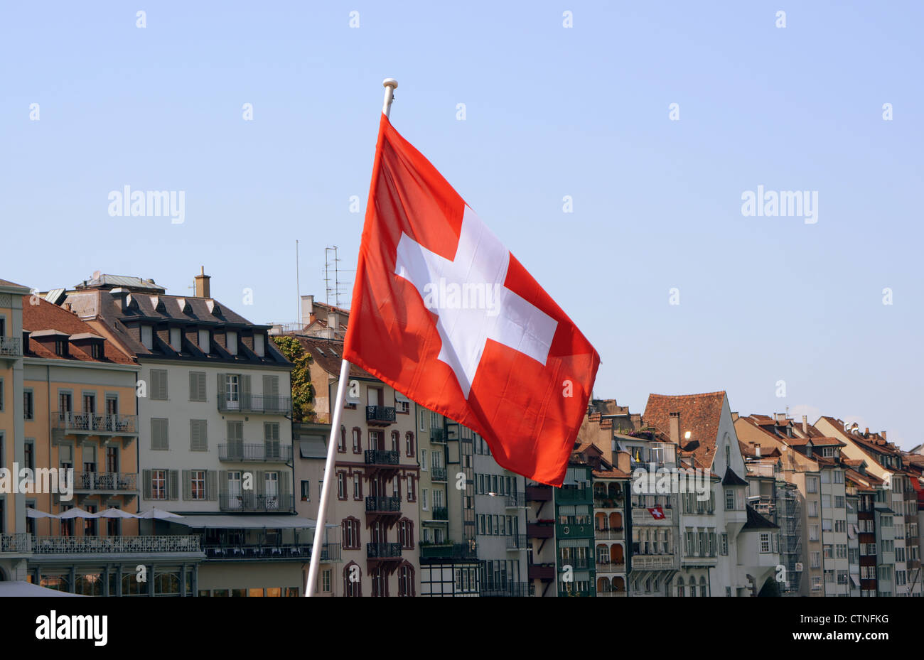 Photo of the Swiss flag with old houses of Basel in the background ...