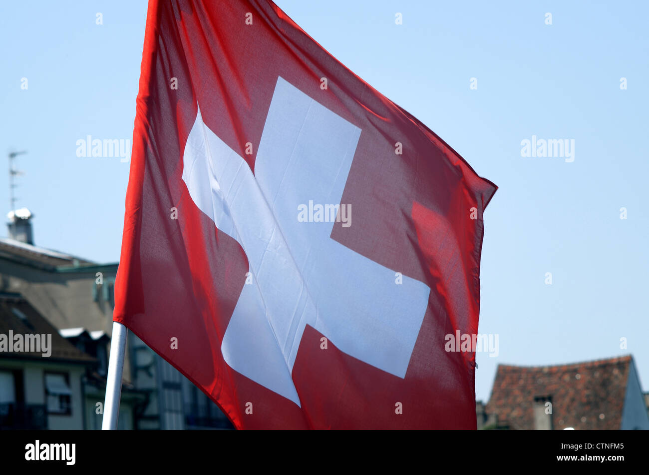 Photo of the Swiss flag with old houses of Basel in the background ...