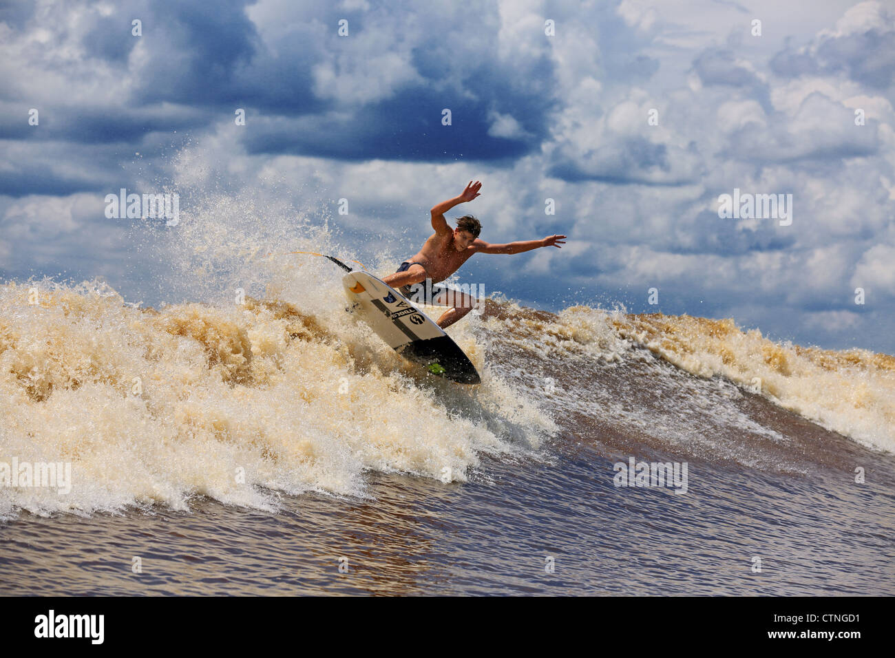 Australian surfer performs air-reverse while surfing on a tidal river ...