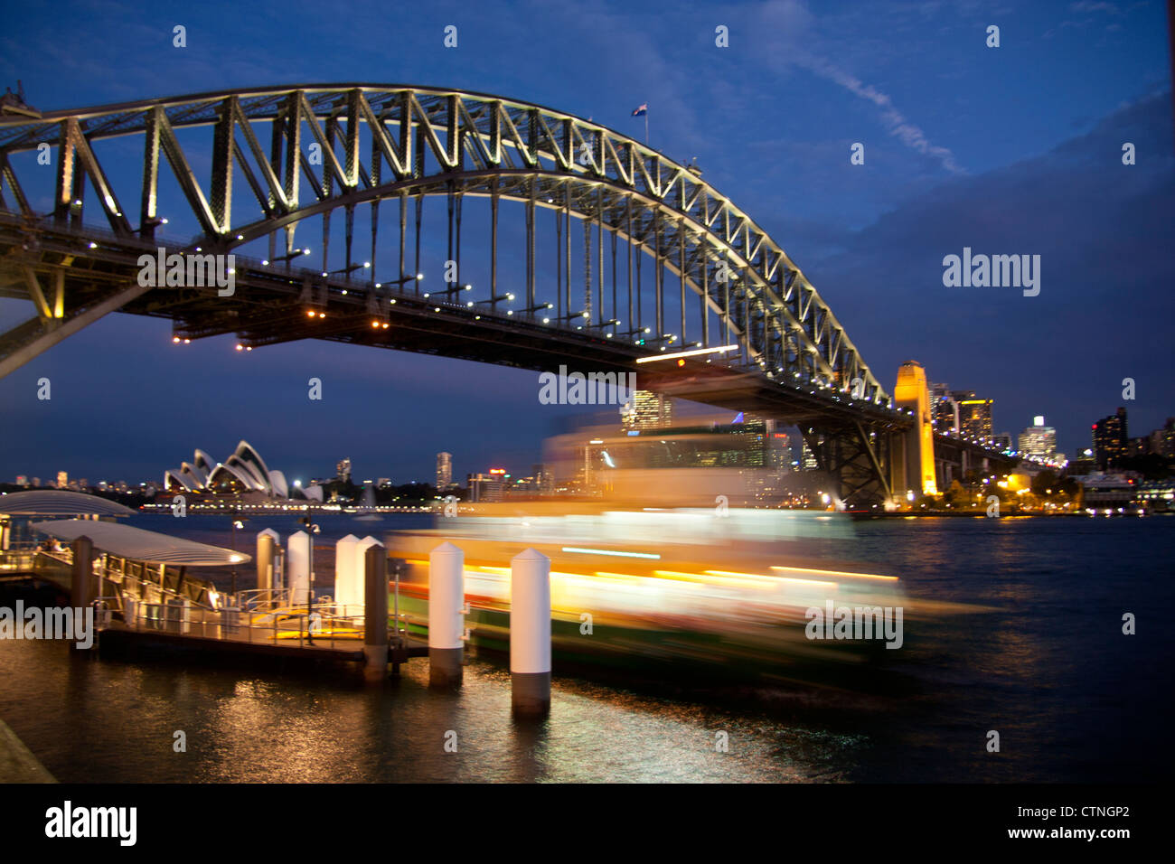 Ferry departing Milsons Point wharf at night with Harbour Bridge and ...