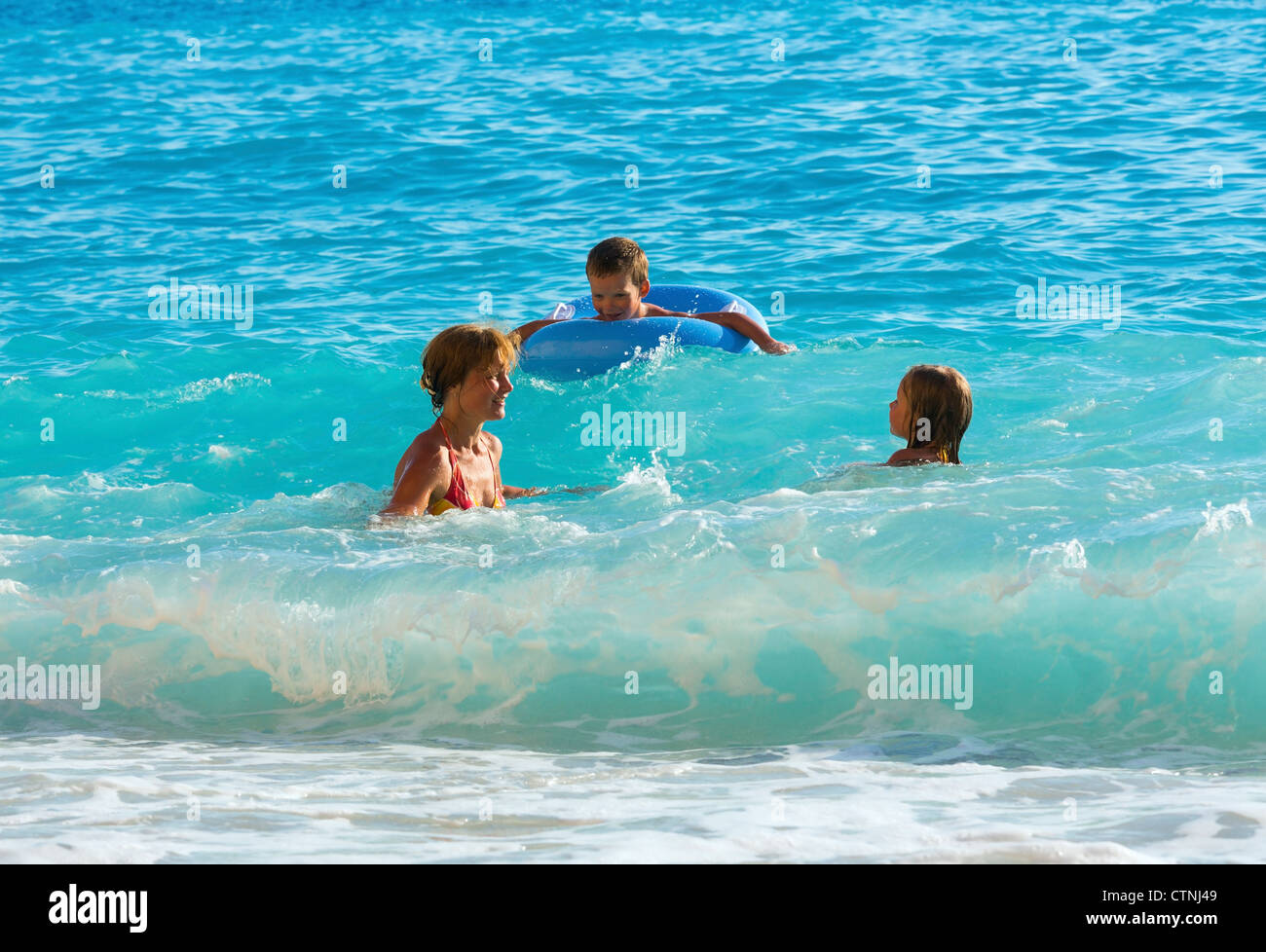Family (mother with two children) have the water-based recreation on ...