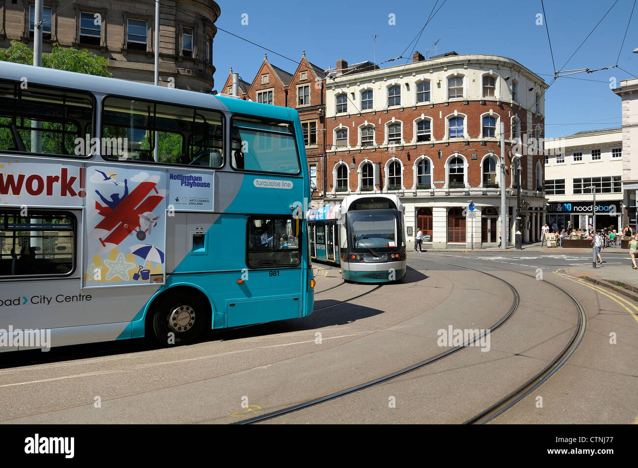 A nottingham city transport bus following a tram on victoria street ...