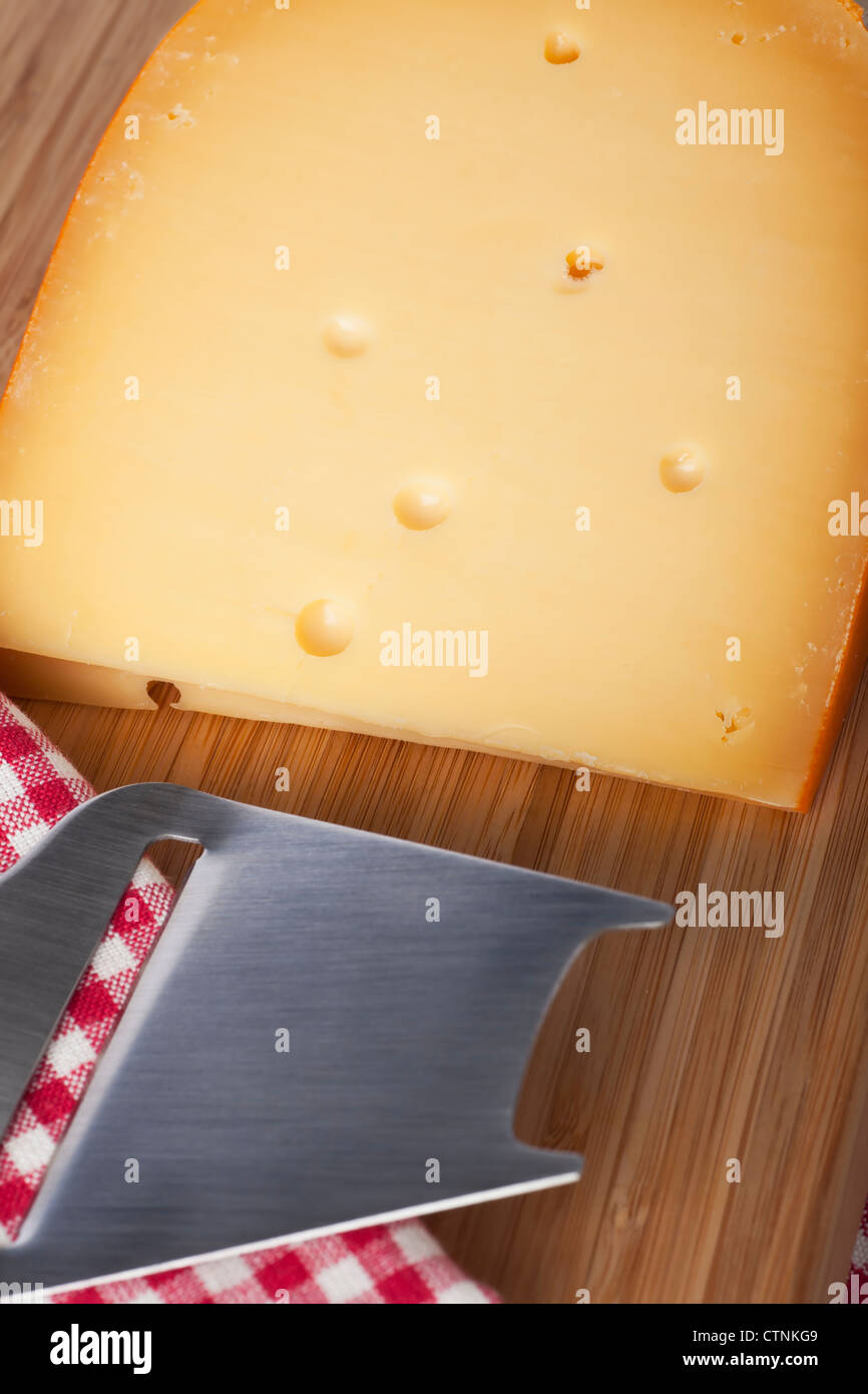 Dutch cheese block with metal cheese slicer Stock Photo - Alamy